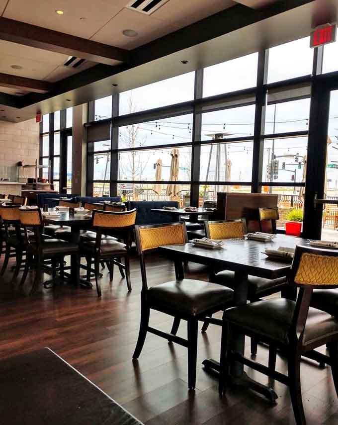 Floor-to-ceiling windows flood the dining room with natural light, creating an airy space that's both contemporary and inviting.