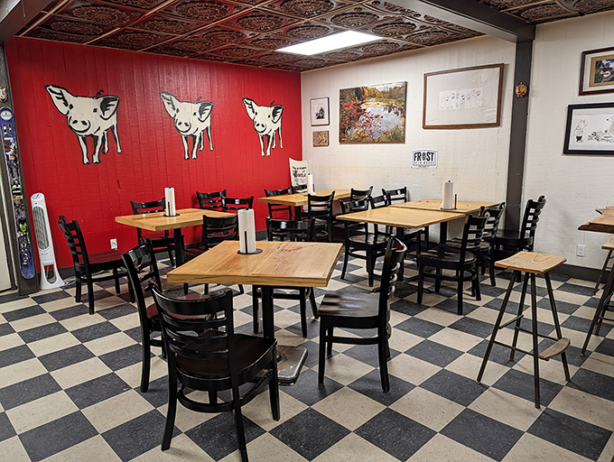 Red walls adorned with playful pig cutouts and classic checkered floors create a casual vibe where the food takes center stage.