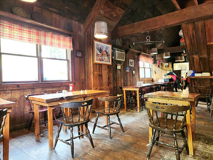 Rustic wooden beams frame a dining room where captain's chairs and simple tables set the stage for Vermont's most memorable breakfast experience.
