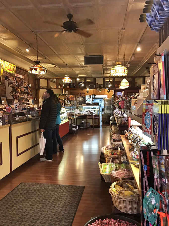 Vintage stained-glass pendant lights cast a warm glow over wooden floors that have supported generations of candy-seeking feet.