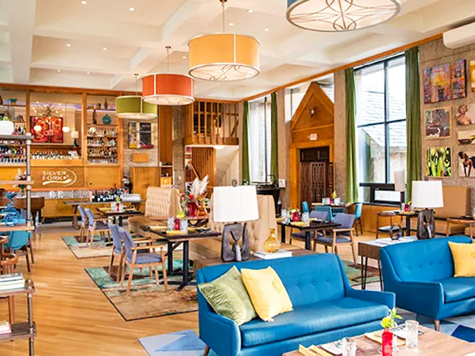 Mid-century modern meets library chic in this vibrant dining room. Those colorful pendant lights aren't just illuminating tables&mdash;they're spotlighting culinary performances.