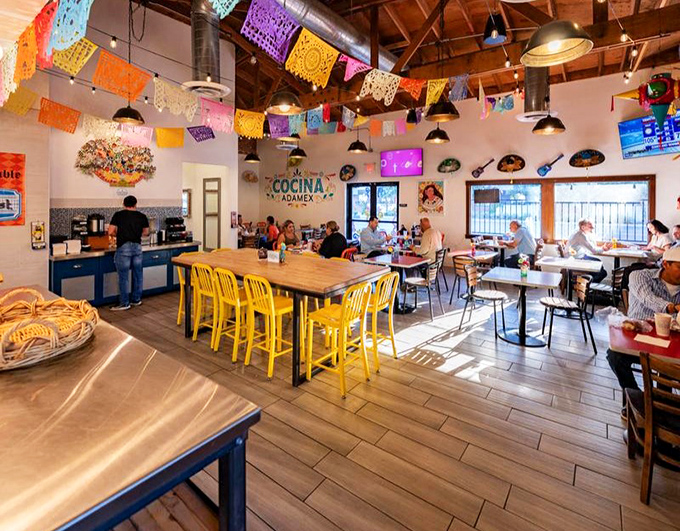 Colorful papel picado banners dance overhead in this cheerful dining room, where every meal feels like a fiesta.