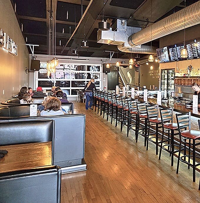 Warm wood tones and industrial chic merge in this inviting space where exposed ductwork and pendant lighting create the perfect backdrop for memorable meals.