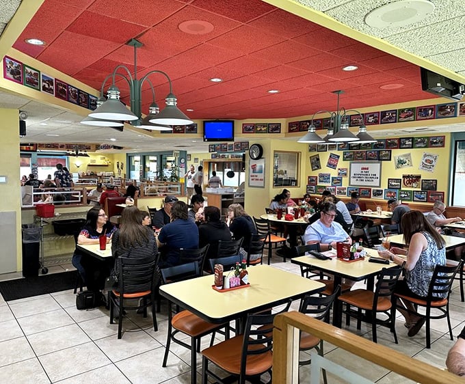Inside, the bustling dining room hums with conversation while the red ceiling and yellow tables create that perfect retro vibe.