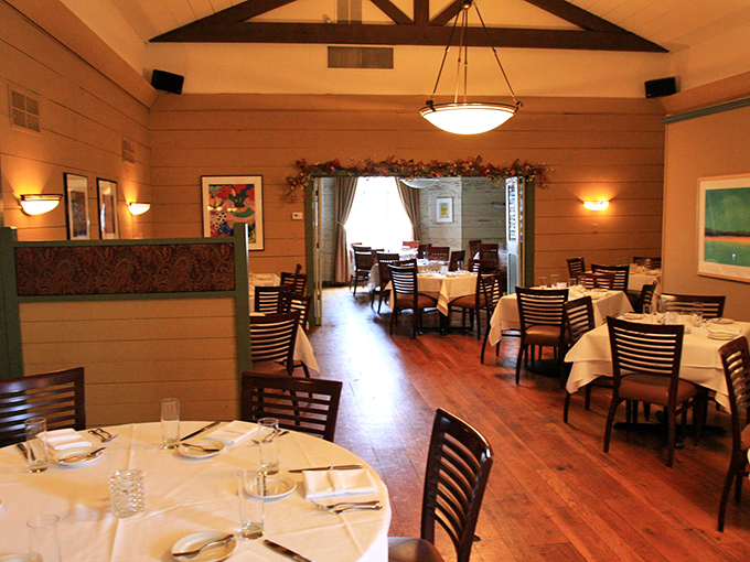 Warm wooden interiors and white tablecloths create that perfect sweet spot between casual comfort and fine dining elegance.