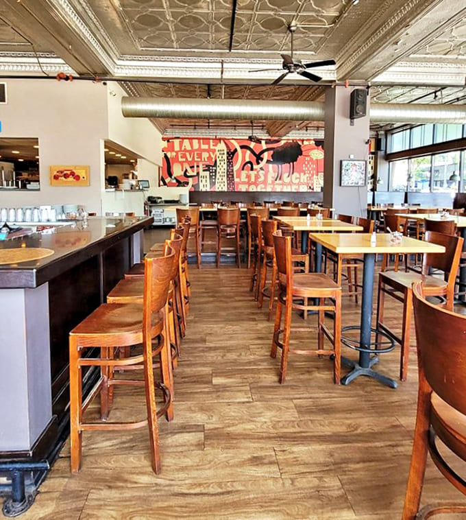 The interior balances industrial chic with cozy comfort, featuring that gorgeous tin ceiling that whispers stories of Minneapolis past.