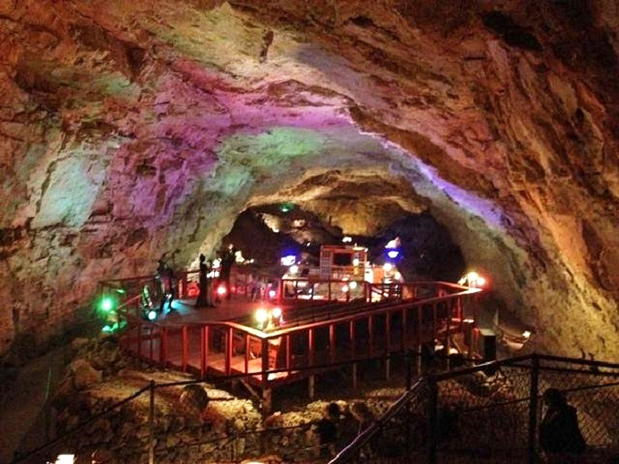 Colorful mood lighting transforms million-year-old limestone into nature's own psychedelic light show. Cave dining at its finest!