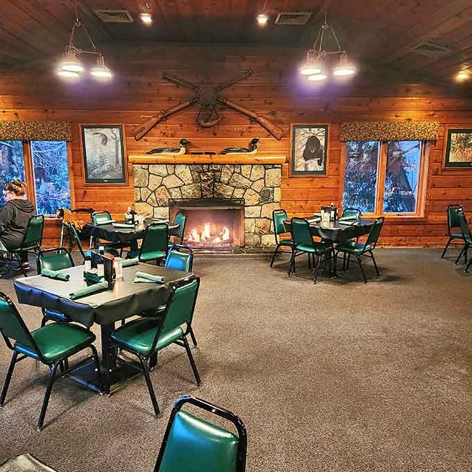 Warm wood paneling, a crackling stone fireplace, and comfortable seating create the perfect backdrop for memorable meals and conversation.