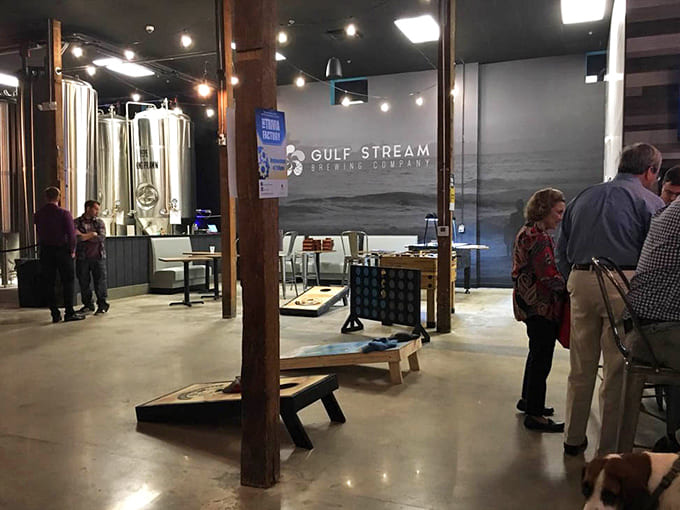 Gleaming steel tanks stand sentinel in the background, brewing liquid gold while patrons enjoy the fruits of fermentation.