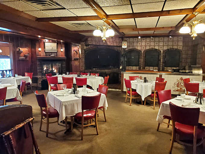 Red chairs pop against crisp white tablecloths in the main dining room, where wood-paneled walls and vintage fixtures create that increasingly rare atmosphere of comfortable elegance.