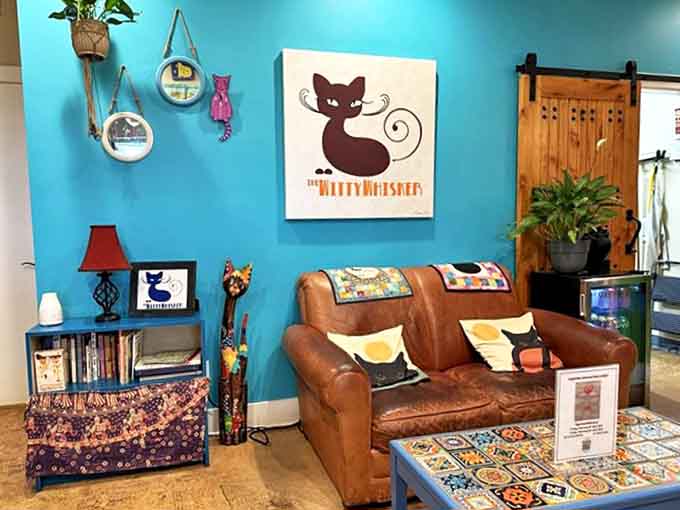Turquoise walls and comfy leather couches create the purr-fect backdrop for feline-human bonding in this cozy lounge area.