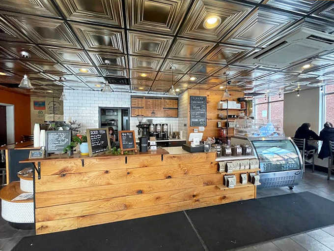 Warm wooden counters meet sleek subway tiles under a stunning tin ceiling &ndash; coffee shop architecture that whispers "stay awhile."