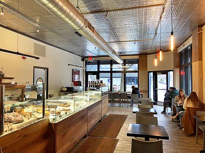 Sleek modern meets rustic charm inside, where pressed tin ceilings and exposed ductwork create the perfect backdrop for pastry perfection.
