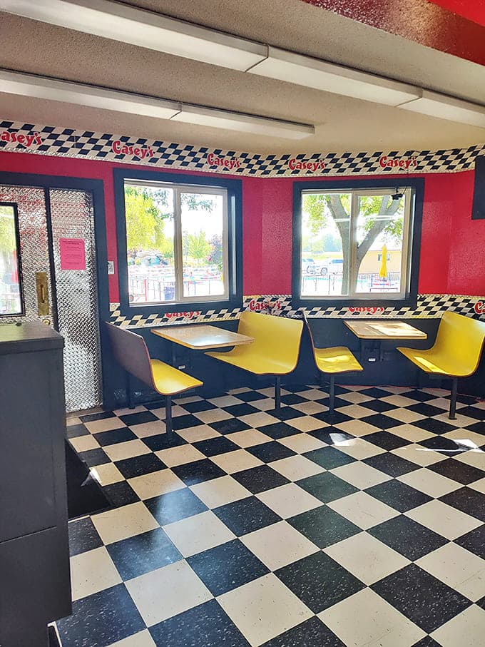 Step back in time at Casey's retro-themed interior, where racing-inspired checkerboard trim and bright yellow bench seating create a nostalgic atmosphere that feels authentically vintage.