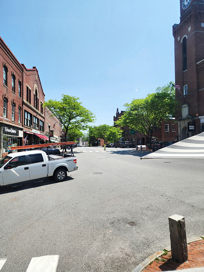 Sunlight bathes the town square, where locals gather and visitors slow down, discovering the rhythm of small-town Vermont life.