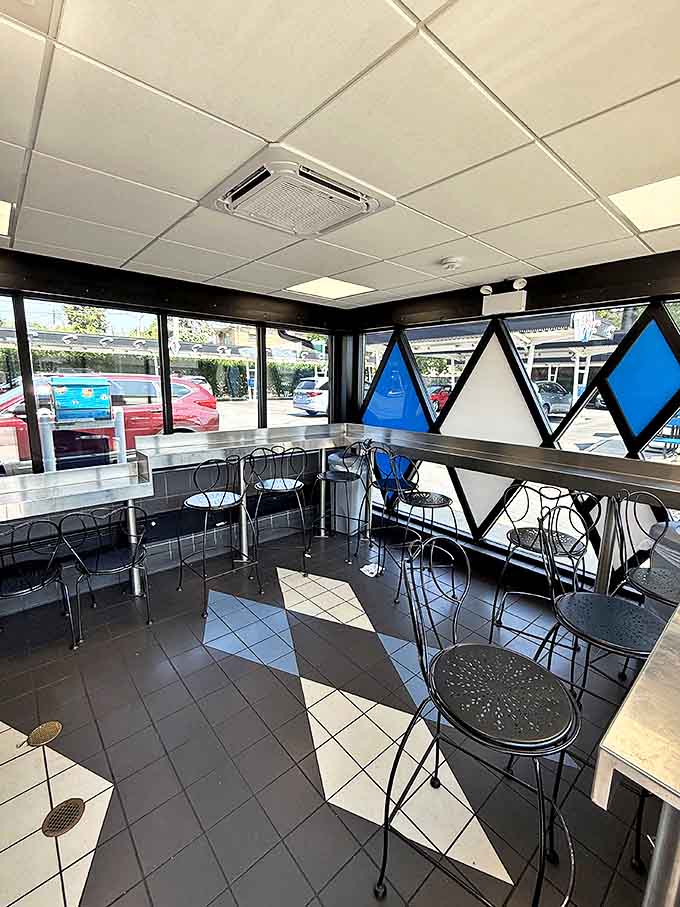 The retro interior features distinctive black and white floors with blue diamond windows, transporting diners to a simpler time when fast food was an event.