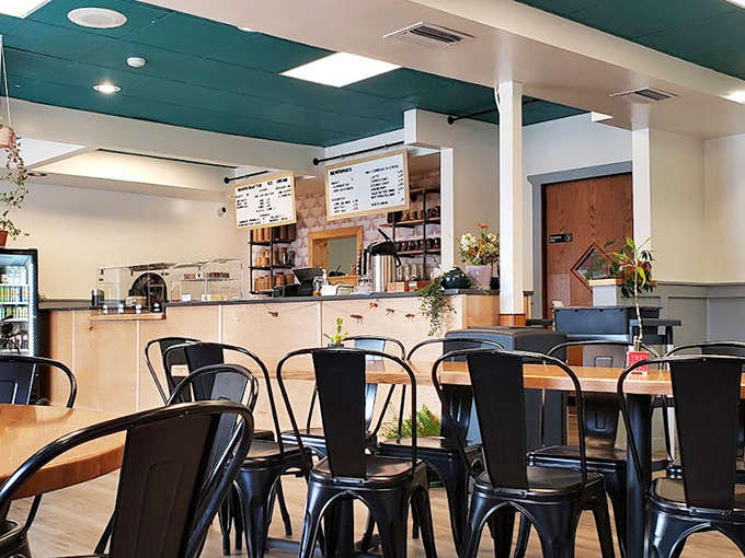 The interior strikes that perfect balance between modern cafe and cozy hangout, with teal ceiling accents and sleek black chairs inviting you to settle in.