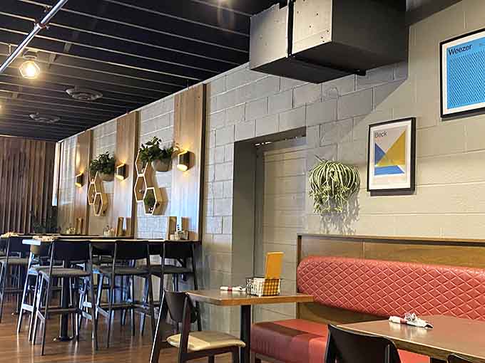 Step inside to discover a modern, inviting space where white subway tiles meet warm wood tones and pops of coral create the perfect backdrop for memorable meals.