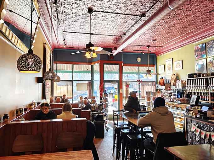 Vintage tin ceilings and warm lighting create an inviting atmosphere where time slows down and coffee tastes better.