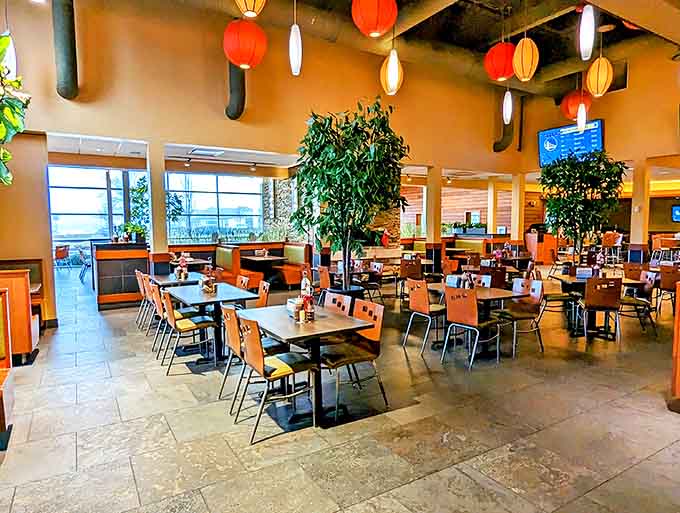 Warm lanterns cast a golden glow over the dining room, where indoor greenery and comfortable seating invite you to settle in for flavor adventures.