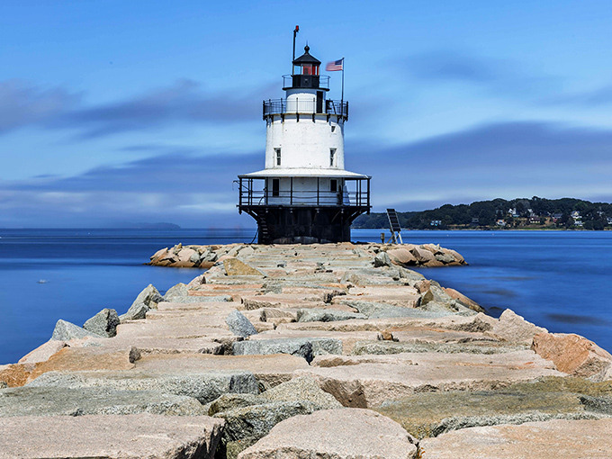 The classic New England lighthouse creates a perfect focal point against the vast blue of Casco Bay.