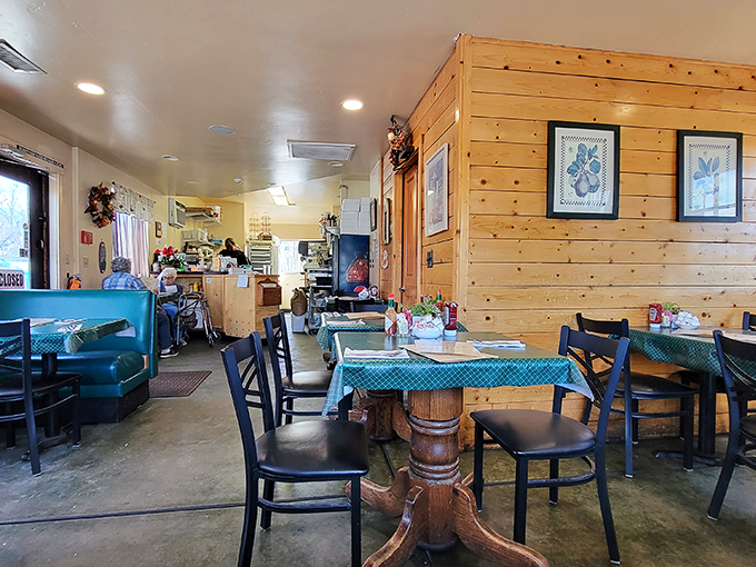 Warm pine walls and teal checkered tablecloths create a cozy cabin feel, where comfort trumps pretension and every table feels like the best seat in the house.