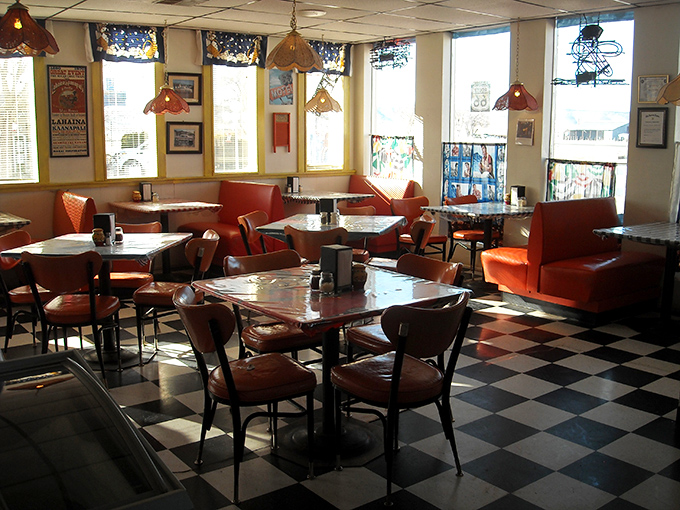 Classic diner charm meets cozy comfort with checkered floors and warm lighting creating the perfect backdrop for pizza revelations.