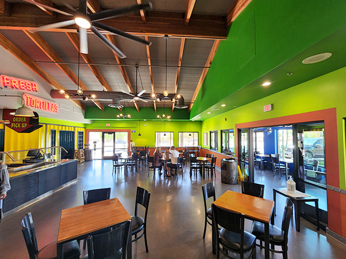 Vibrant lime green walls and exposed wooden beams create a cheerful atmosphere where the only thing more colorful than the decor is the food.