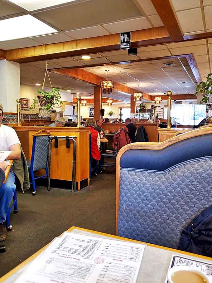 Wood paneling, blue booths, and hanging lights create that perfect diner atmosphere where time slows down and conversations flow freely.