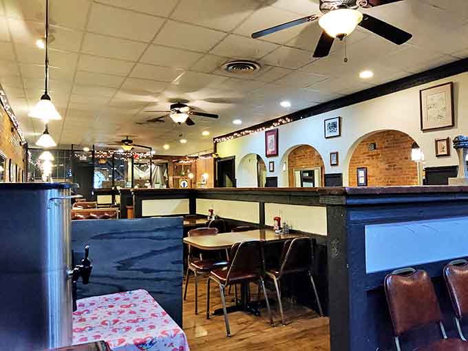 Step inside to discover a cozy interior where ornate tin ceiling tiles cast a warm glow over green walls adorned with local artwork.