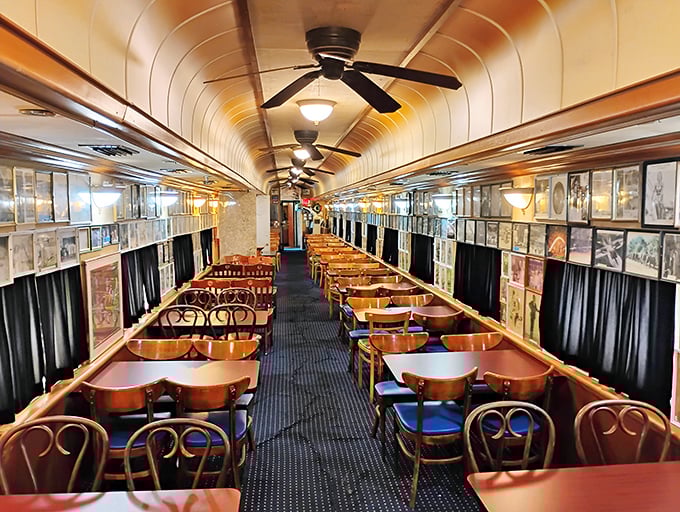 Polished wood tables stretch the length of the vintage dining car, where ceiling fans spin lazily above conversations that flow as easily as the coffee.