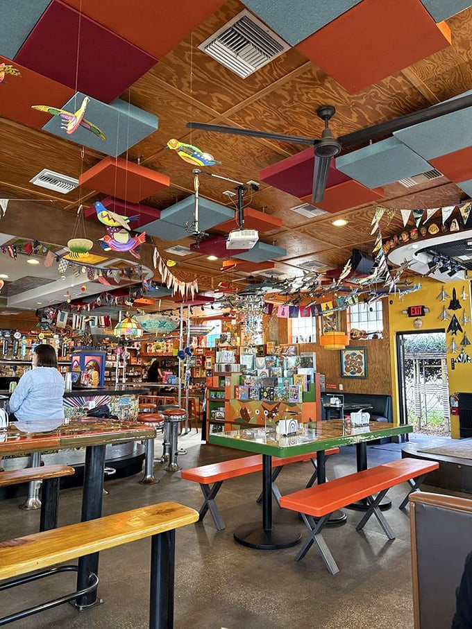 Colorful ceiling panels and hanging birds create a whimsical indoor atmosphere where every glance reveals something new to discover.