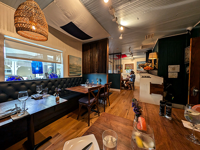 Cozy elegance defines the interior, where woven lamp shades cast warm light across leather banquettes and wooden tables ready for seafood feasts.