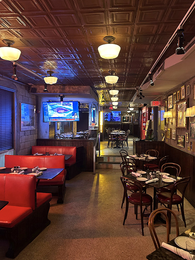 Step inside to discover a warm interior where copper ceiling tiles reflect golden light, red booths invite lingering conversations, and Miami Beach nostalgia lines the walls.