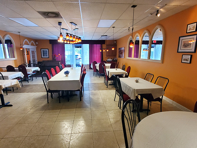 The warm, inviting dining room balances elegance with homey comfort &ndash; white tablecloths meet orange walls in a space where memories are made between bites.