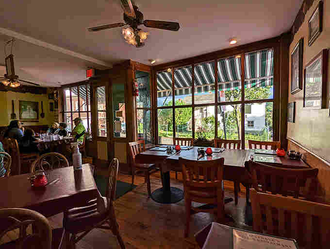 Wooden tables dressed in burgundy cloths sit beneath dim lighting, while the dining room quietly remembers family celebrations and first dates.