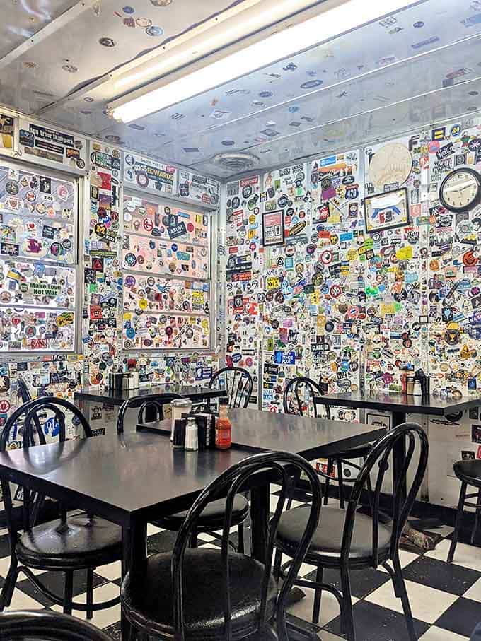 Every available surface tells a story in stickers, creating a visual feast before you even order your actual feast.