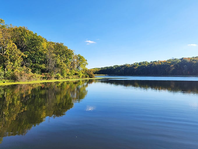 Mirror-like waters at Lake Le-Aqua-Na reflect autumn's golden touch, creating nature's perfect symmetry.