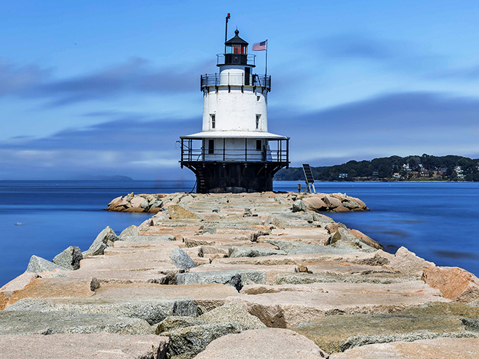 The iconic white tower rises from its granite foundation, a maritime sentinel that's been guiding ships safely through Portland Harbor for generations.