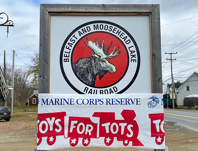 The iconic Belfast and Moosehead Lake Railroad sign welcomes visitors, its bold moose silhouette promising wilderness adventures just a train ride away.