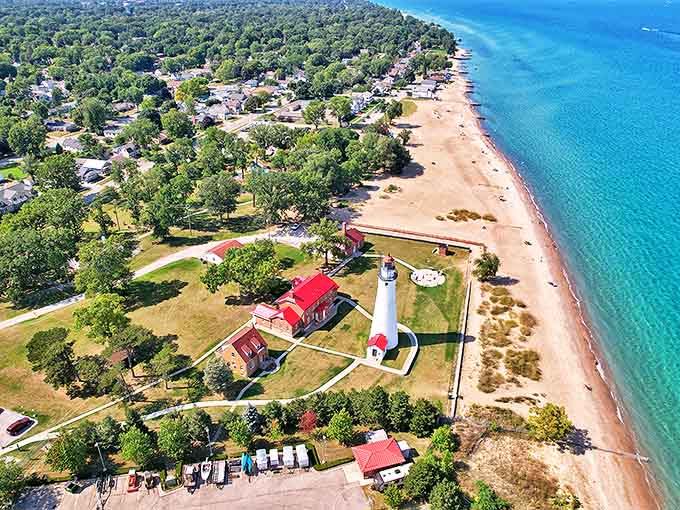 A bird's-eye view reveals the lighthouse's strategic position where Lake Huron meets the St. Clair River, surrounded by sandy beaches and azure waters.