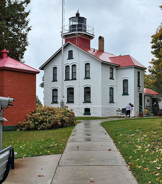 A welcoming pathway leads visitors to the lighthouse entrance, where maritime history and Great Lakes lore await the curious explorer.