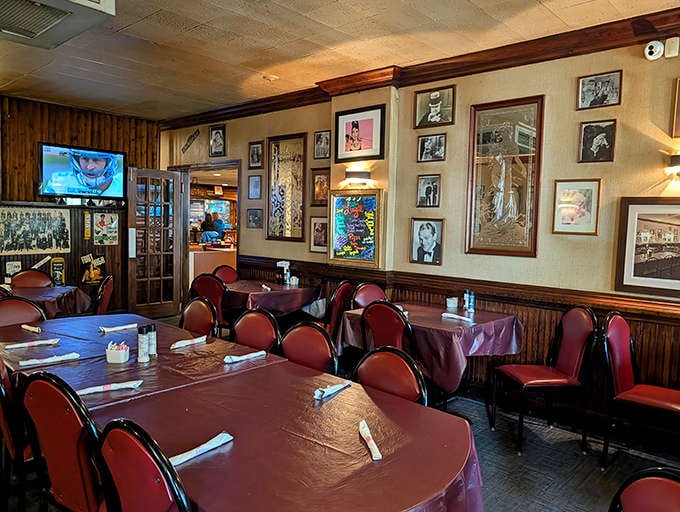Wood paneling, burgundy tablecloths, and vintage photos create a nostalgic dining atmosphere that feels wonderfully frozen in time.