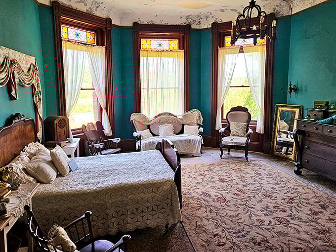This teal-walled bedroom, with its bay windows and period furnishings, makes modern hotel rooms look as exciting as waiting at the DMV.