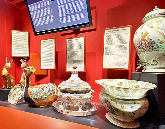 Vibrant Chinese porcelain pieces tell stories of ancient craftsmanship against a dramatic red backdrop, each curve and color a whisper from dynasties past.