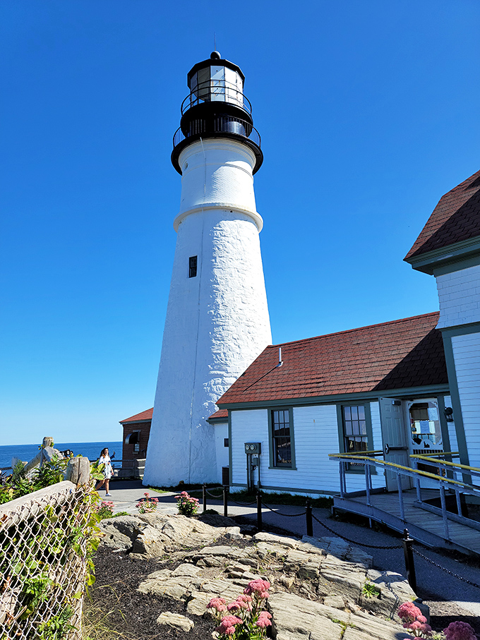 Gleaming white against azure skies, the lighthouse tower has guided mariners safely home since George Washington's presidency.