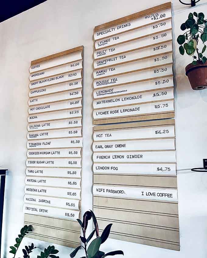 The wooden menu board reads like a passport to flavor country &ndash; where every beverage is designed to complement your pastry adventure.