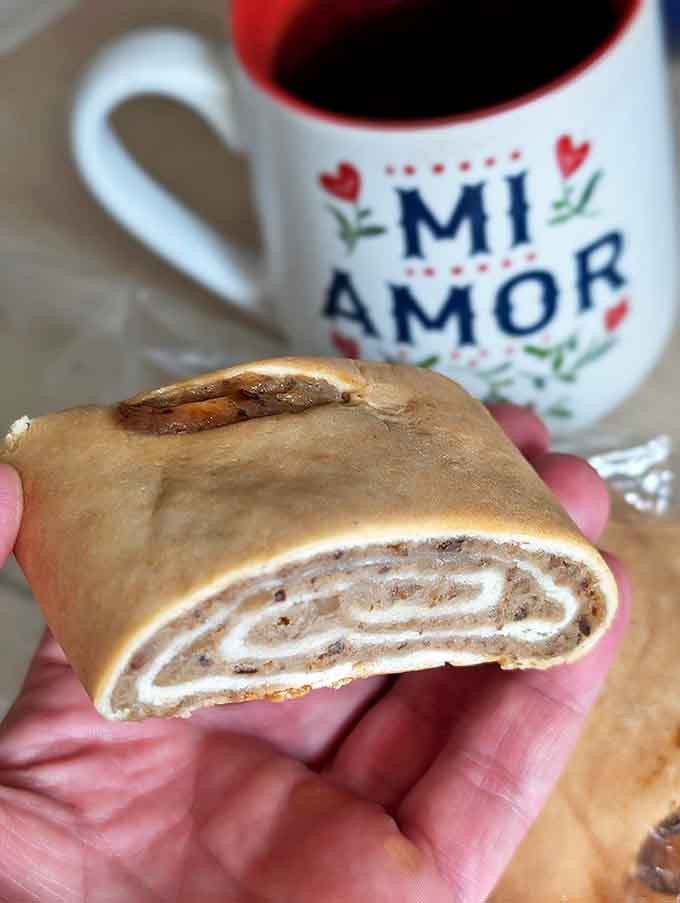 A perfect pairing: the legendary nut roll slice meets its match in a steaming cup of coffee, creating a moment of pure Ohio bliss.