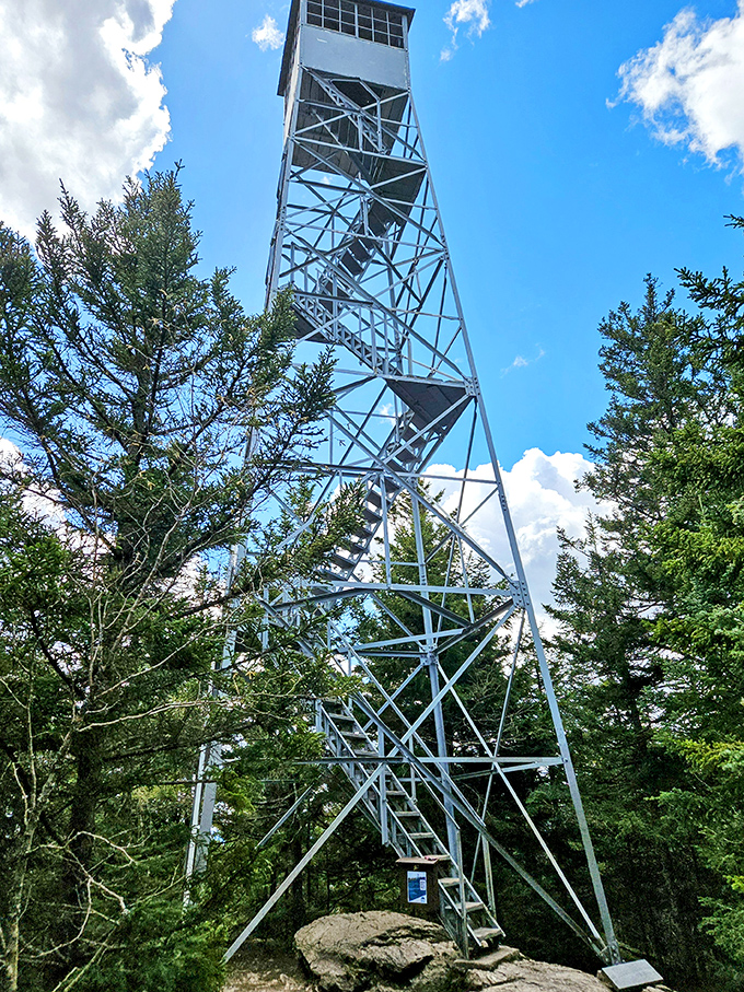 The fire tower stands like a metal sentinel, challenging visitors with its dizzying climb and promising spectacular rewards.