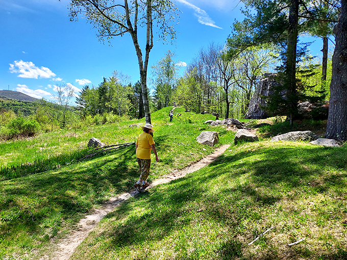 A visitor in bright yellow explores the winding trails, demonstrating why comfortable shoes are the unofficial uniform of Taconic Mountains Ramble.